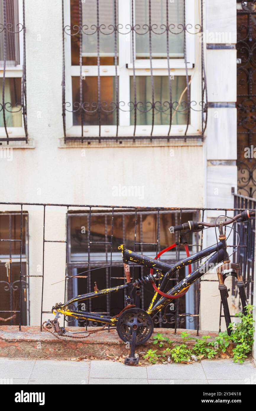 An old bicycle frame without wheels parked by a fence Stock Photo - Alamy