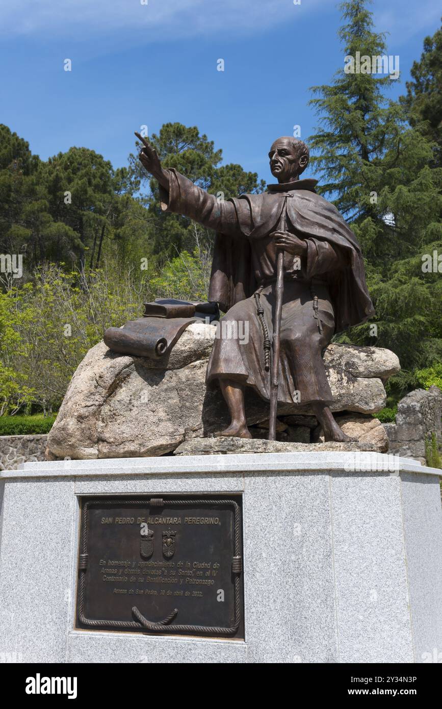 Bronze statue of a monk with walking stick on a stone pedestal in the ...