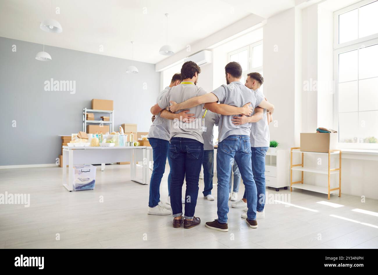 The men, hugging each other, stand in a circle in the room Stock Photo ...