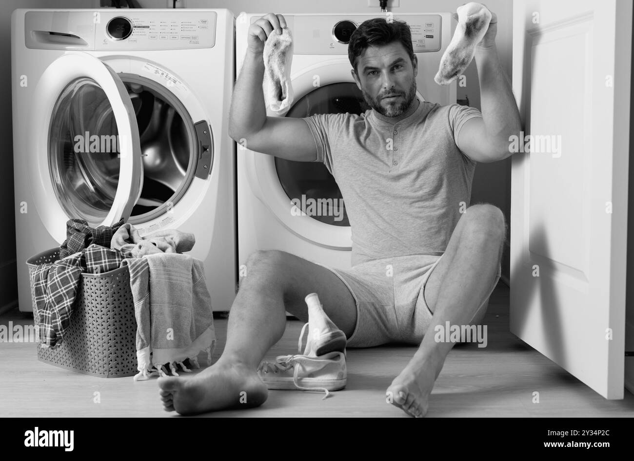 Man with clothes near washing machine. Laundry cleaning. Housework ...