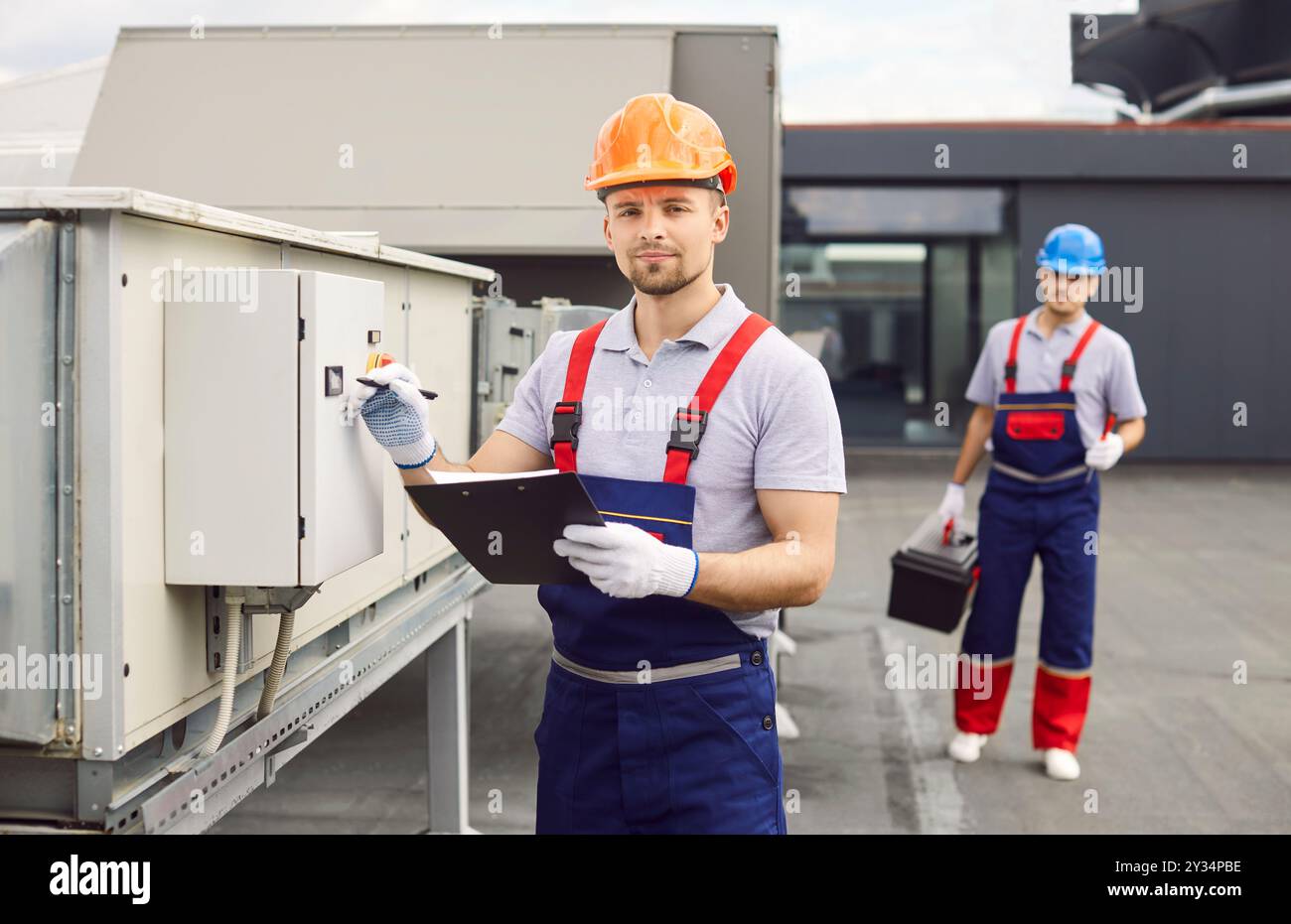 Focused Worker Inspecting HVAC System on Roof Stock Photo - Alamy