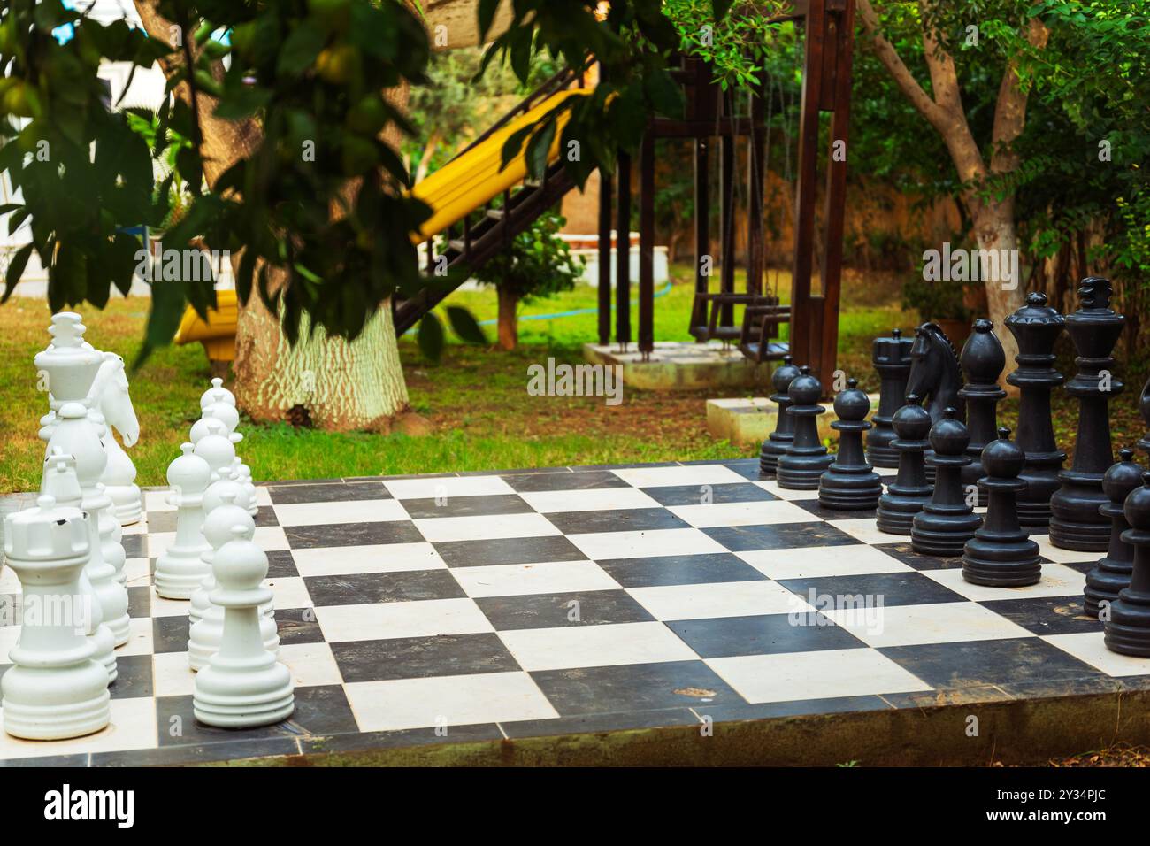 A large chess board featuring oversized giant chess pieces placed on it ...