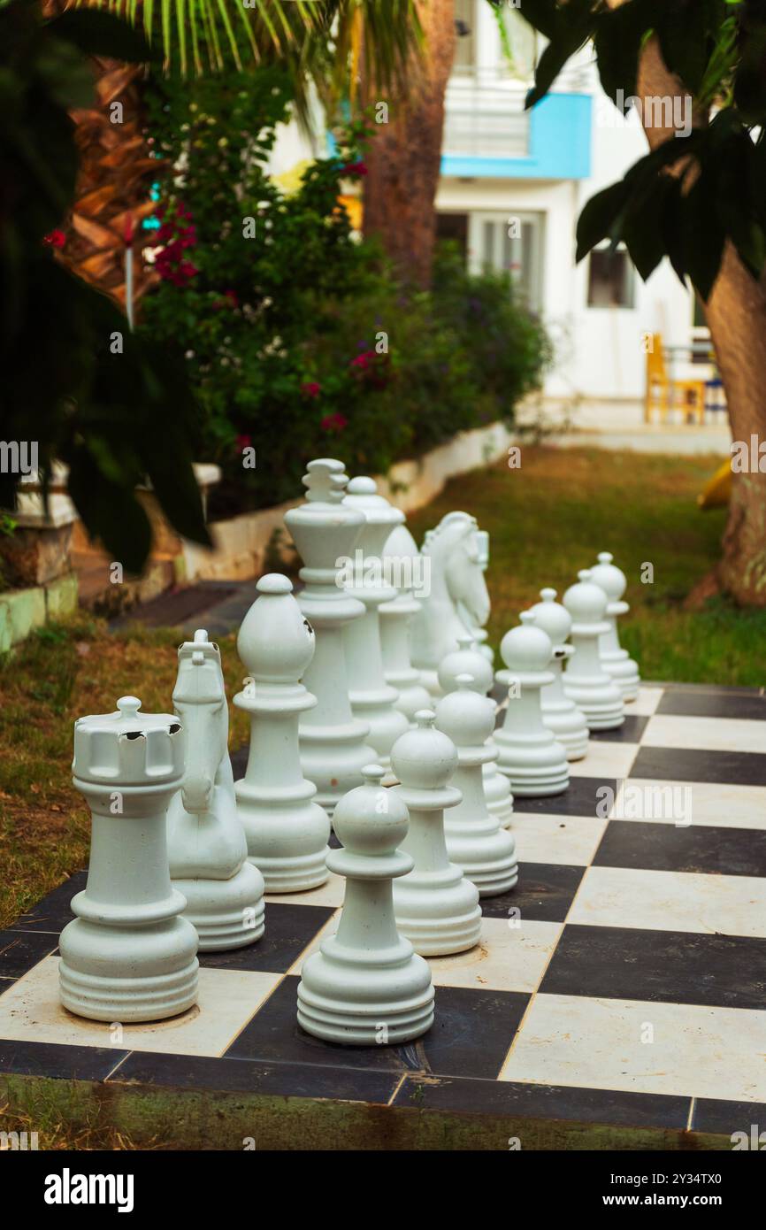 A large chess board featuring oversized giant chess pieces placed on it ...