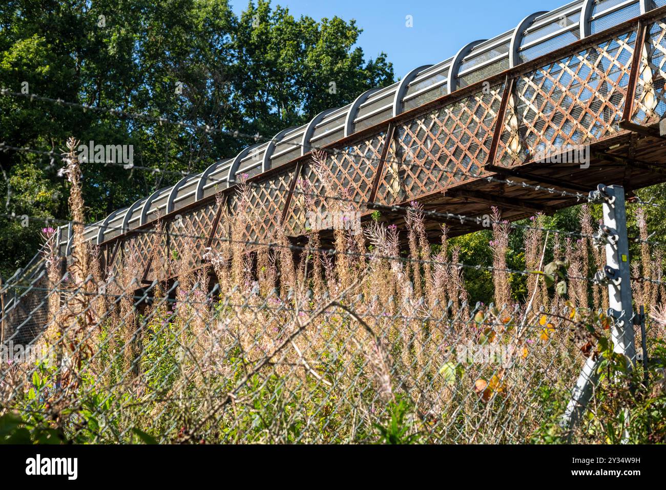 Metal cage like enclosed footbridge over a railway line in Petts Wood ...