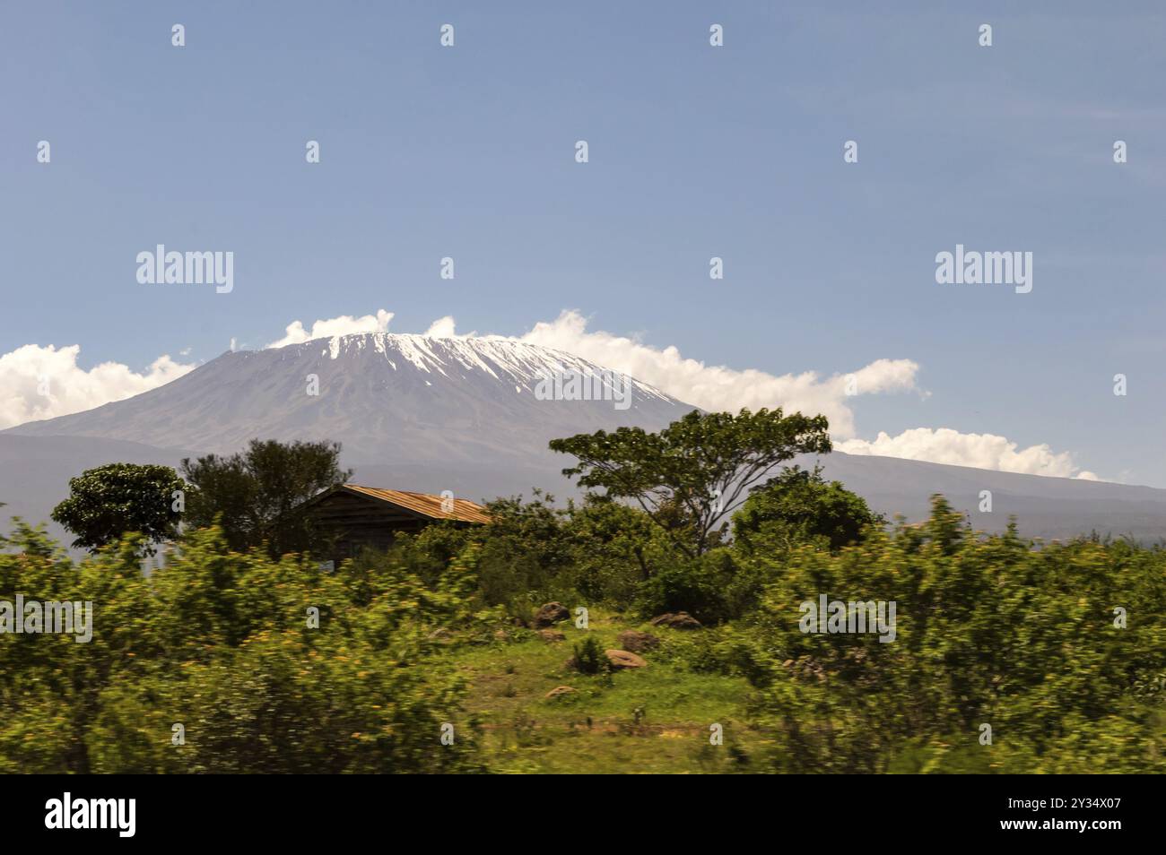 Snow capped Kenya's Kilimanjaro mountain under cloudy blue sky captured ...