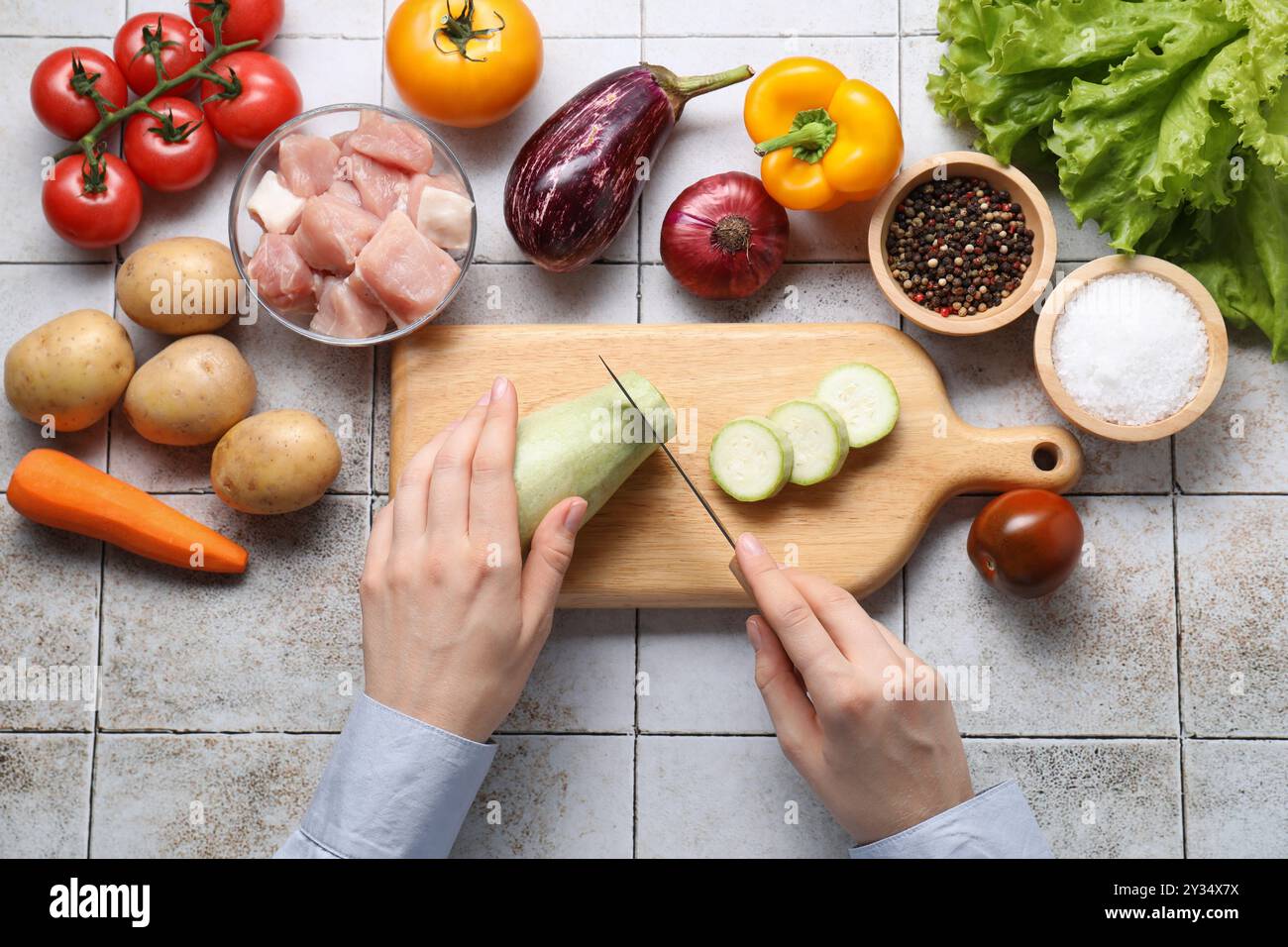 Woman cooking stew at tiled table, top view Stock Photo - Alamy
