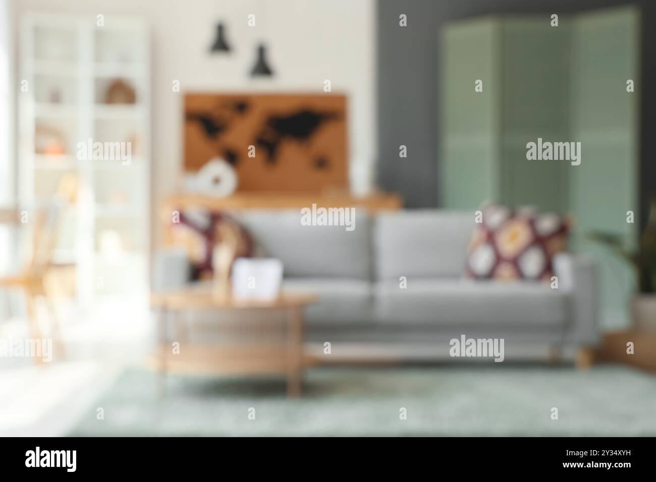 Blurred view of living room with sofa and world map near white wall ...