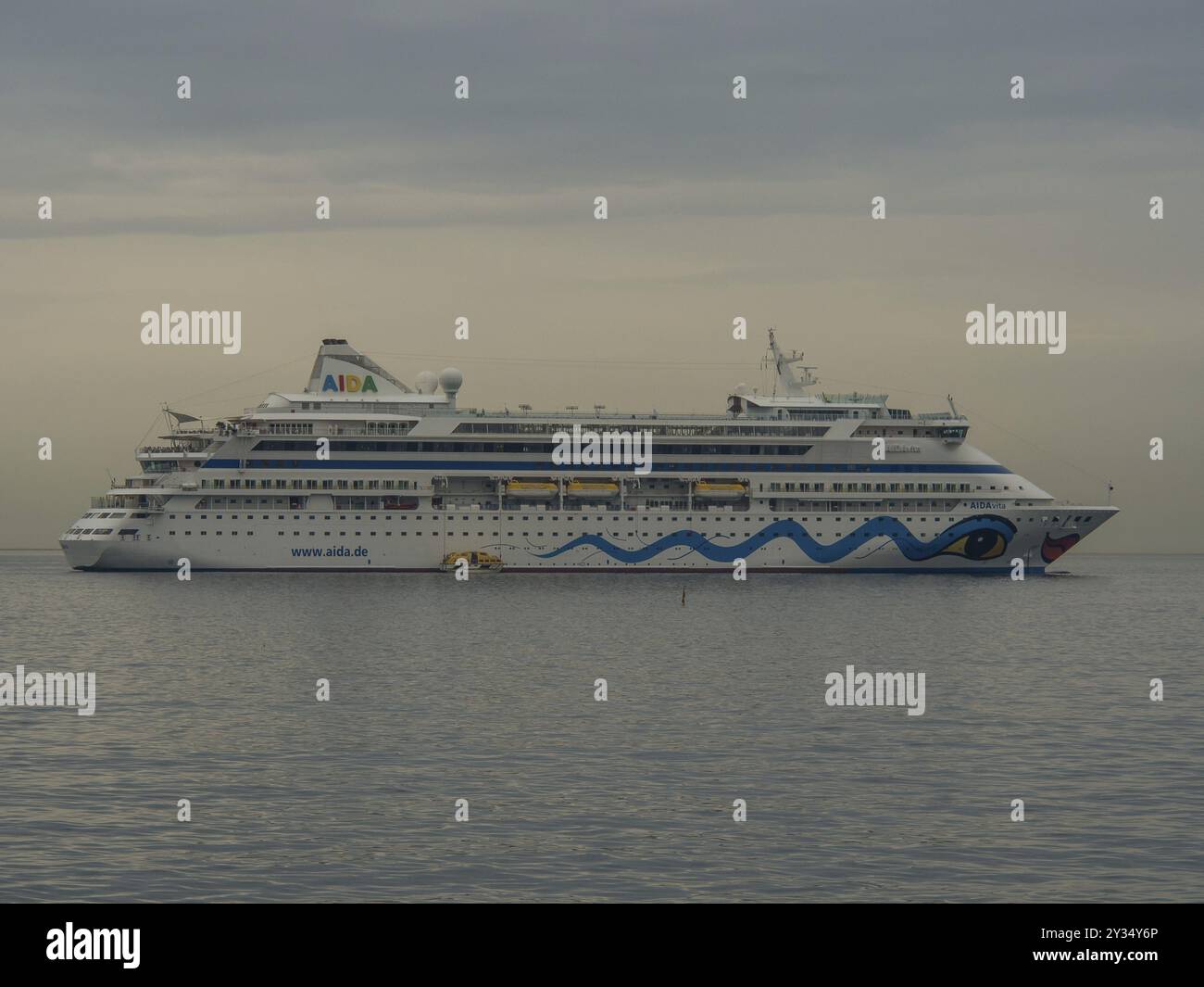 Cruise ship with blue wave patterns sailing on calm sea under cloudy ...