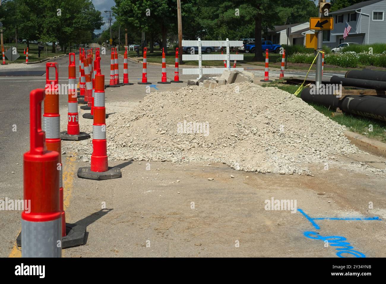 Traffic cones, a gravel pile, and pipe sections mark the start of a ...