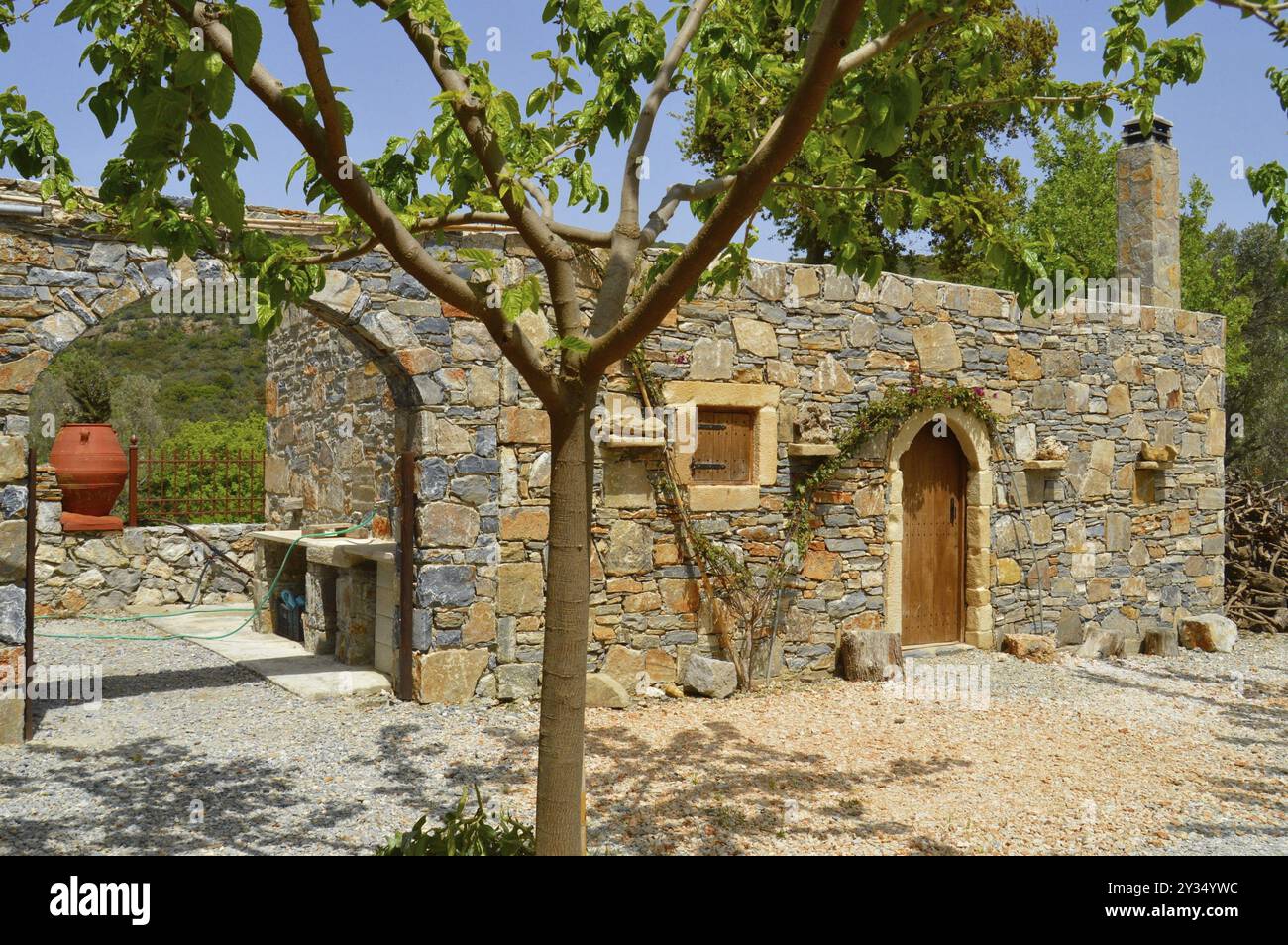 Blue stone Cretan typical house with a vineyard and a window and a ...