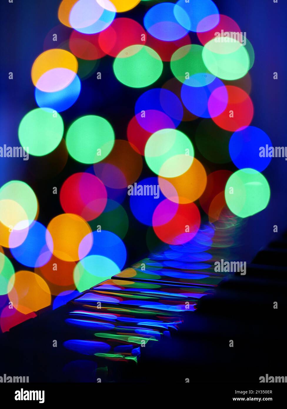 Blurred bokeh Christmas lights reflected in piano keys. Christmas and ...