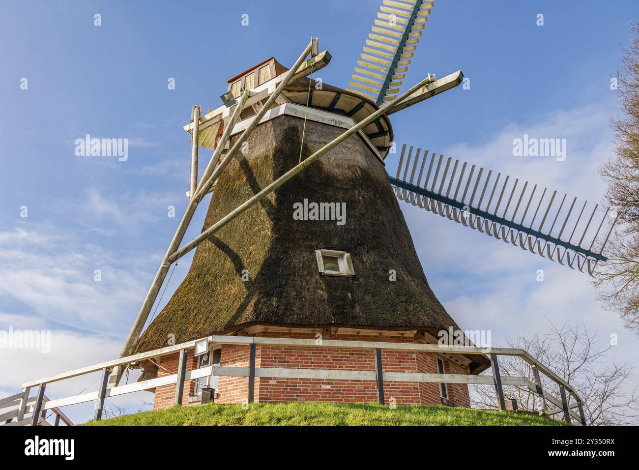 Traditional windmill with thatched roof and wooden construction under a ...