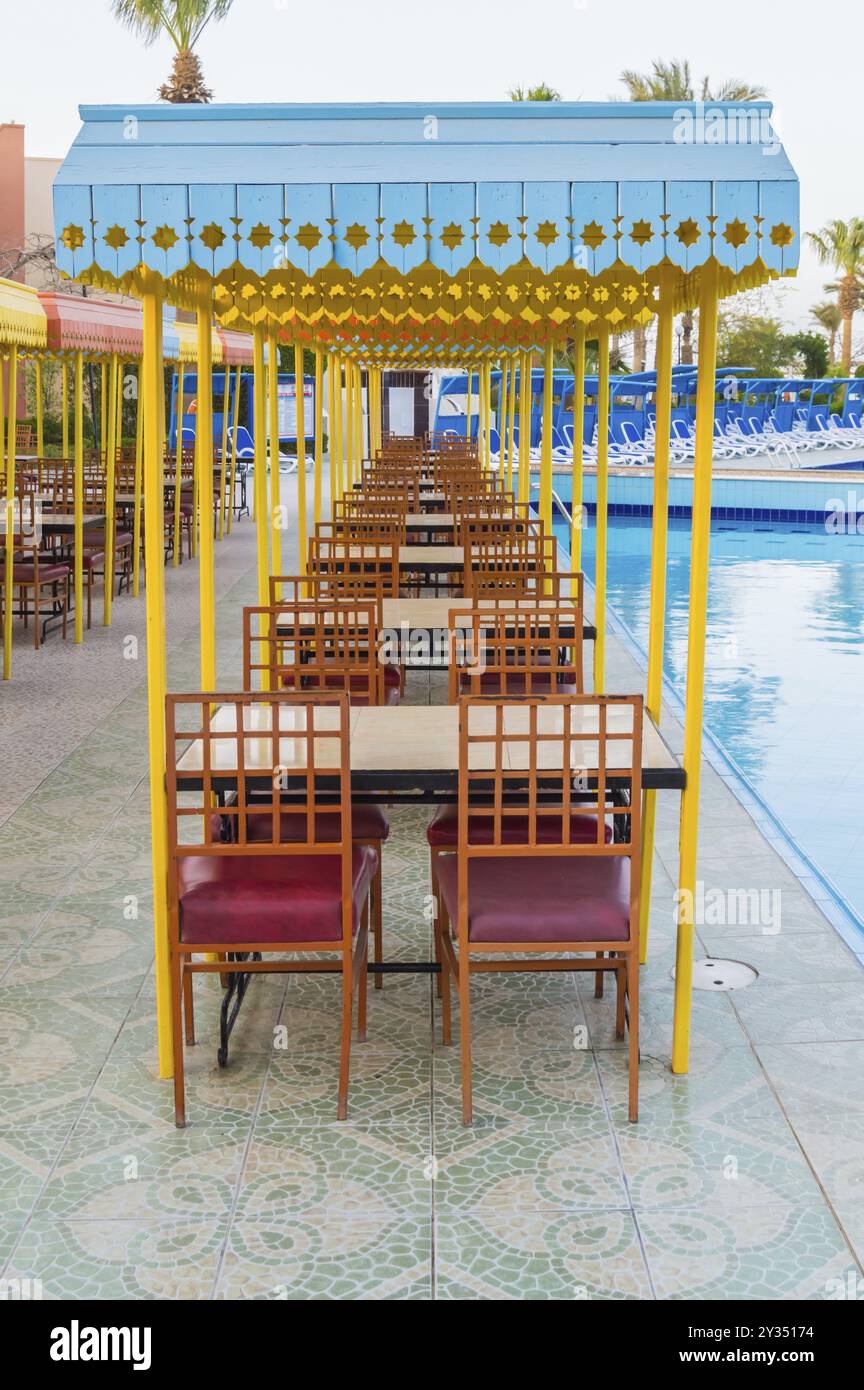 Outdoor wooden restaurant terrace with tables with four seats with a ...