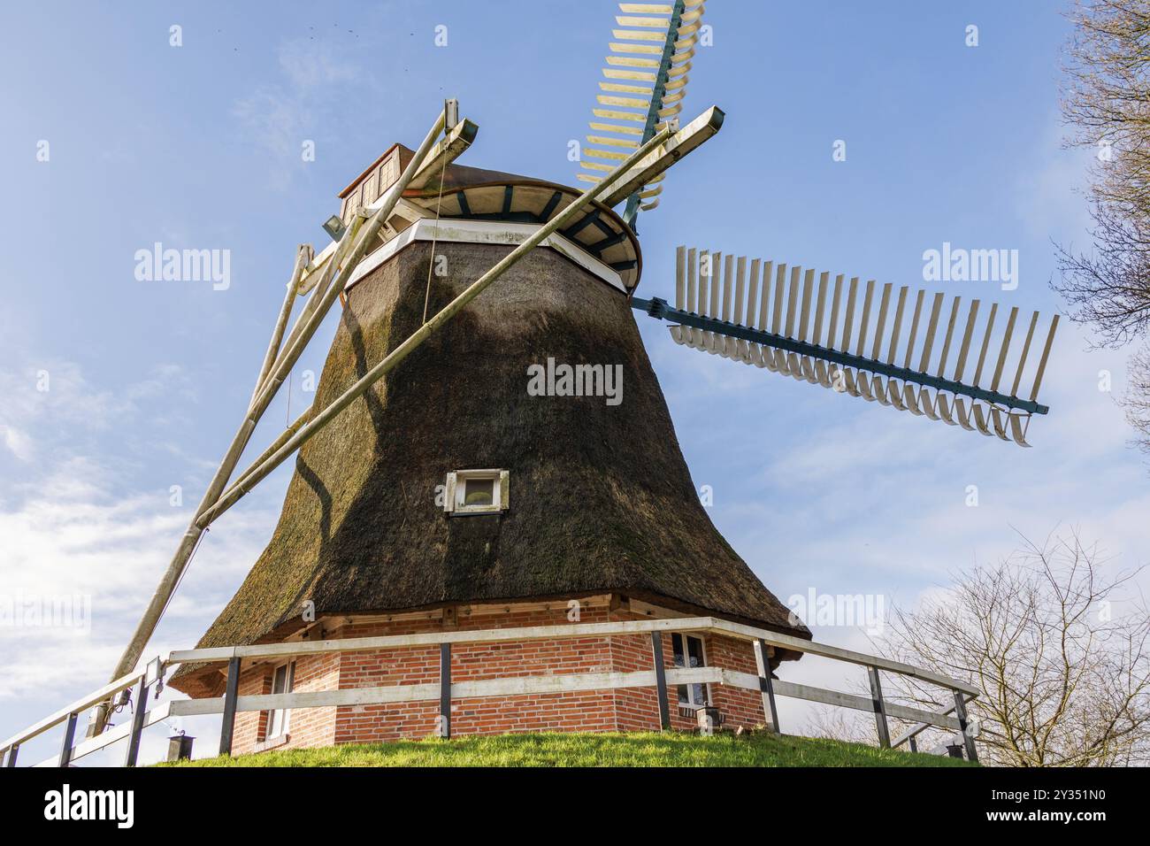 Traditional windmill with thatched roof and wooden construction under a ...