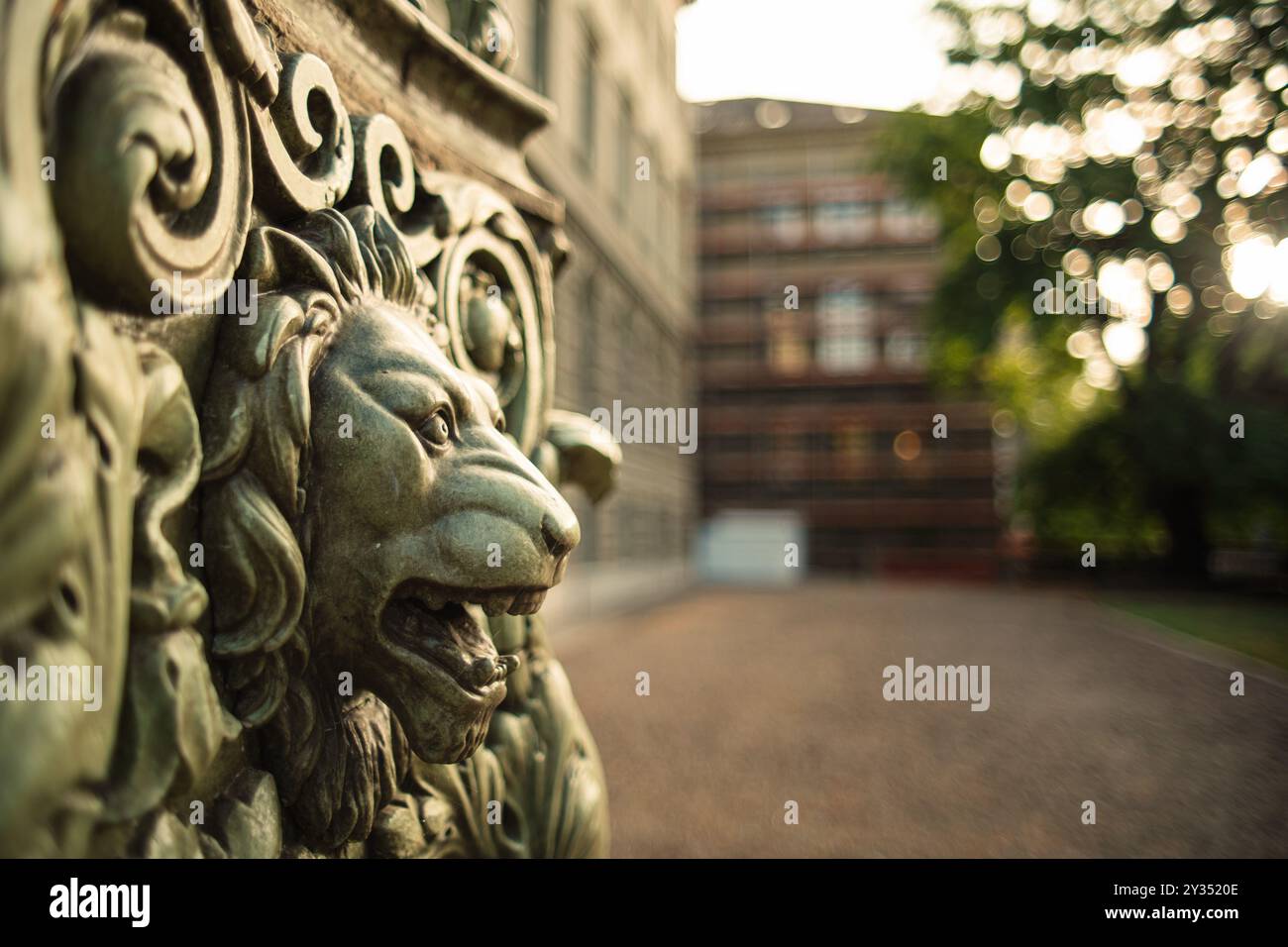 Old, metal sculpted lion head statue. Close up shot of head and mane ...