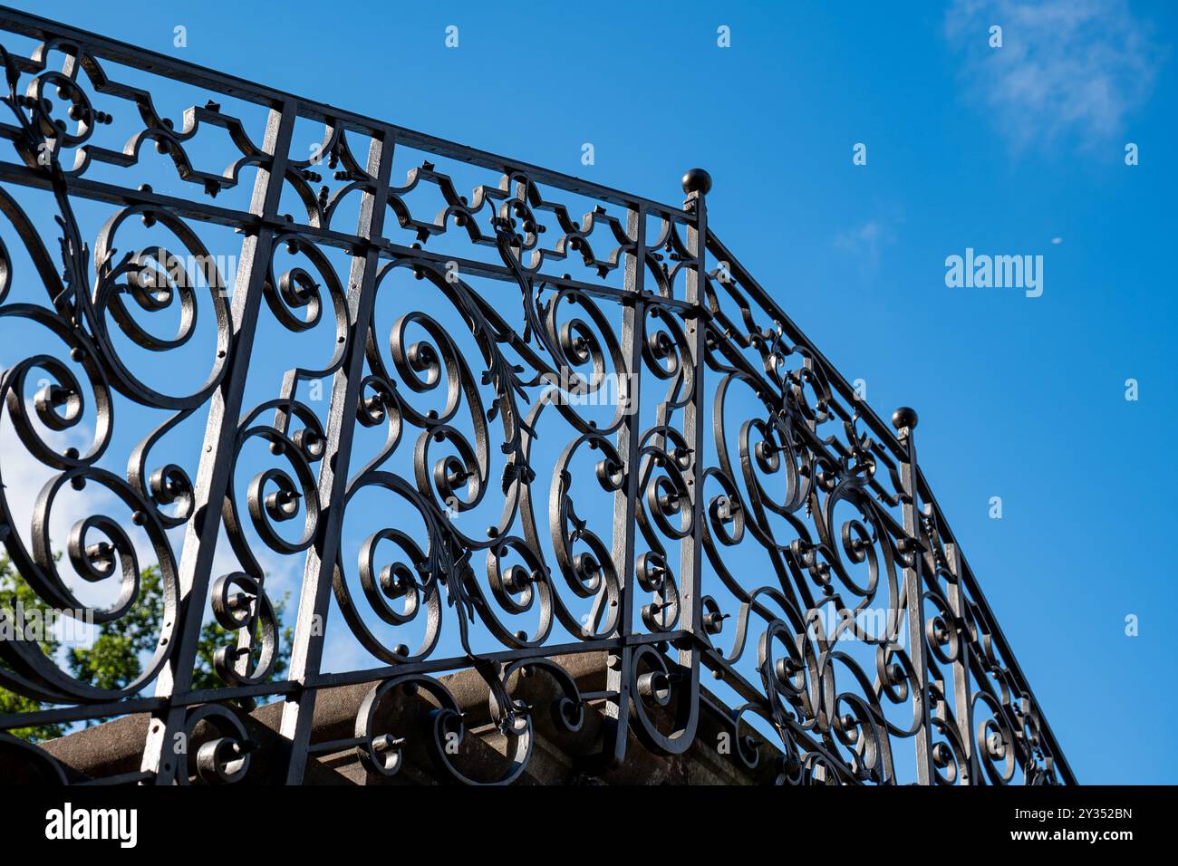 Wrought Iron balcony railing. Looking up shot, blue sky in the ...