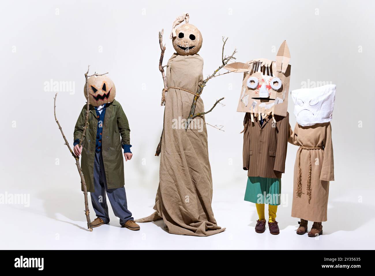 Group of people wearing eerie masks and oversized robes. Giant pumpkin ...