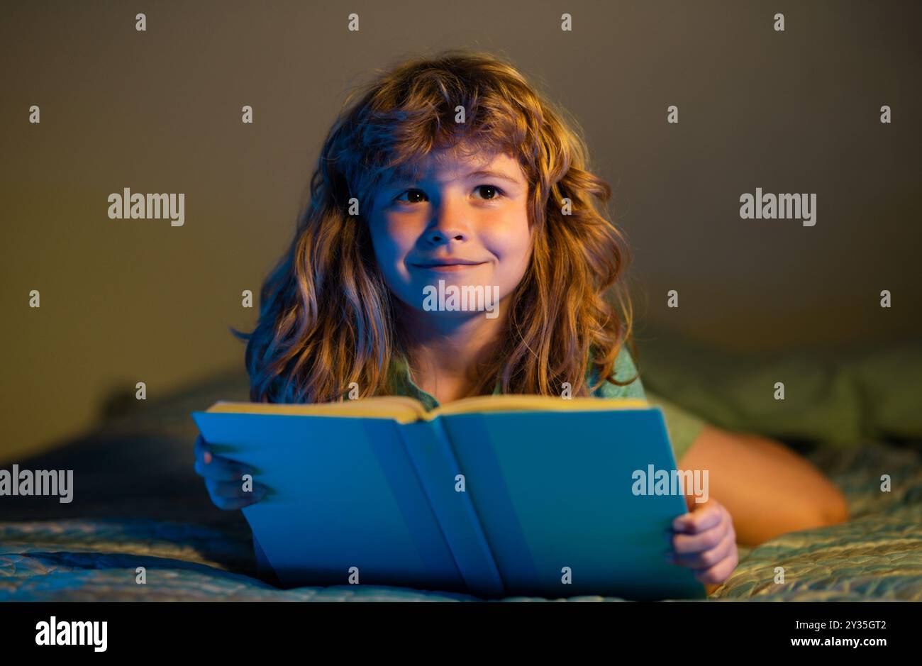 Child boy reading book. Child reading a book in bed before going to ...