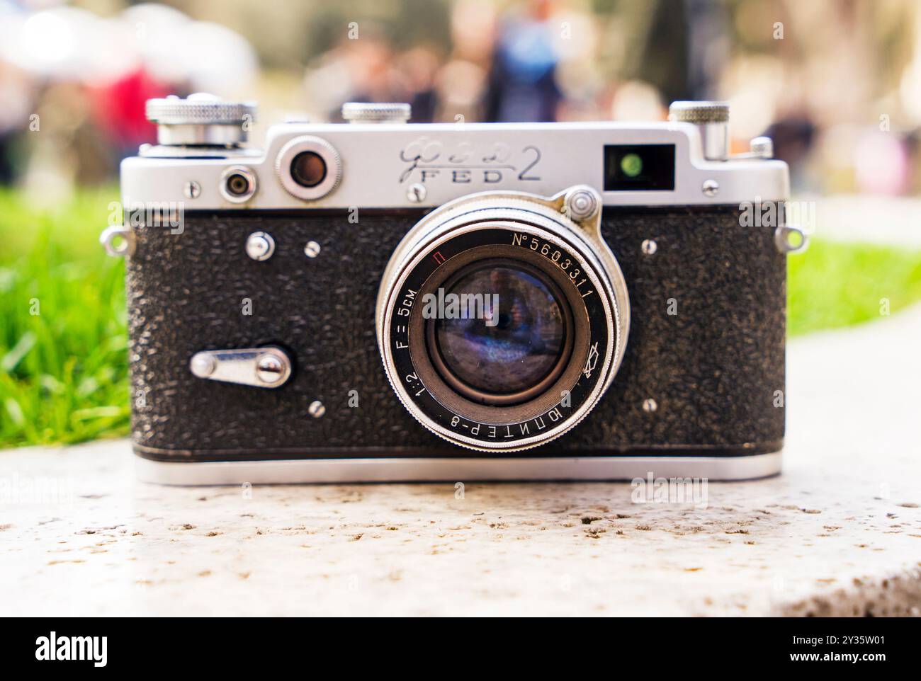 Vintage digital camera on boulder over blurred nature background ...
