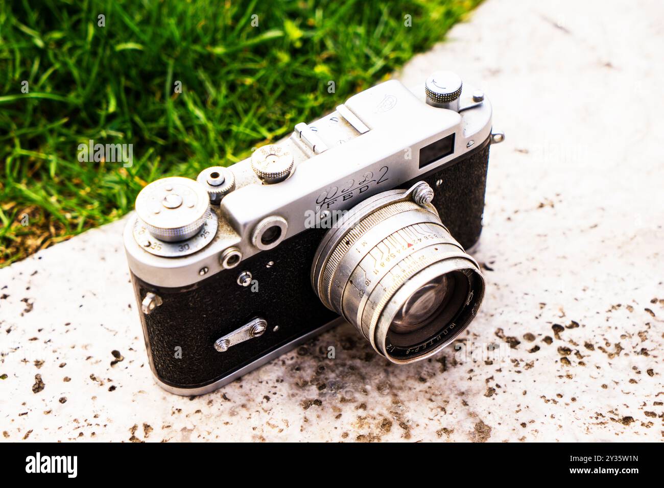 Vintage digital camera on boulder over blurred nature background ...