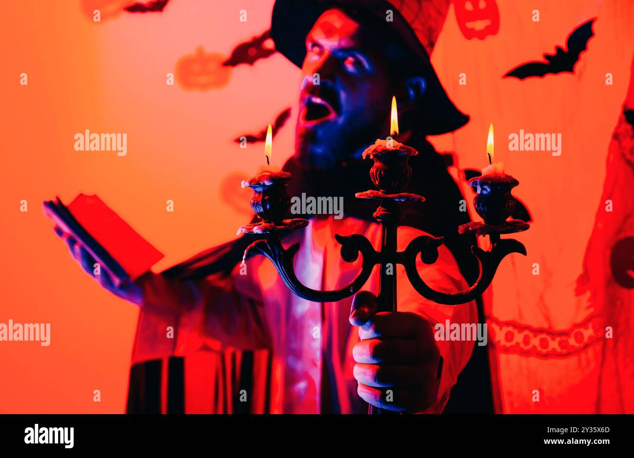 Halloween decoration and scary concept. Man pronounces a spell, reads a ...