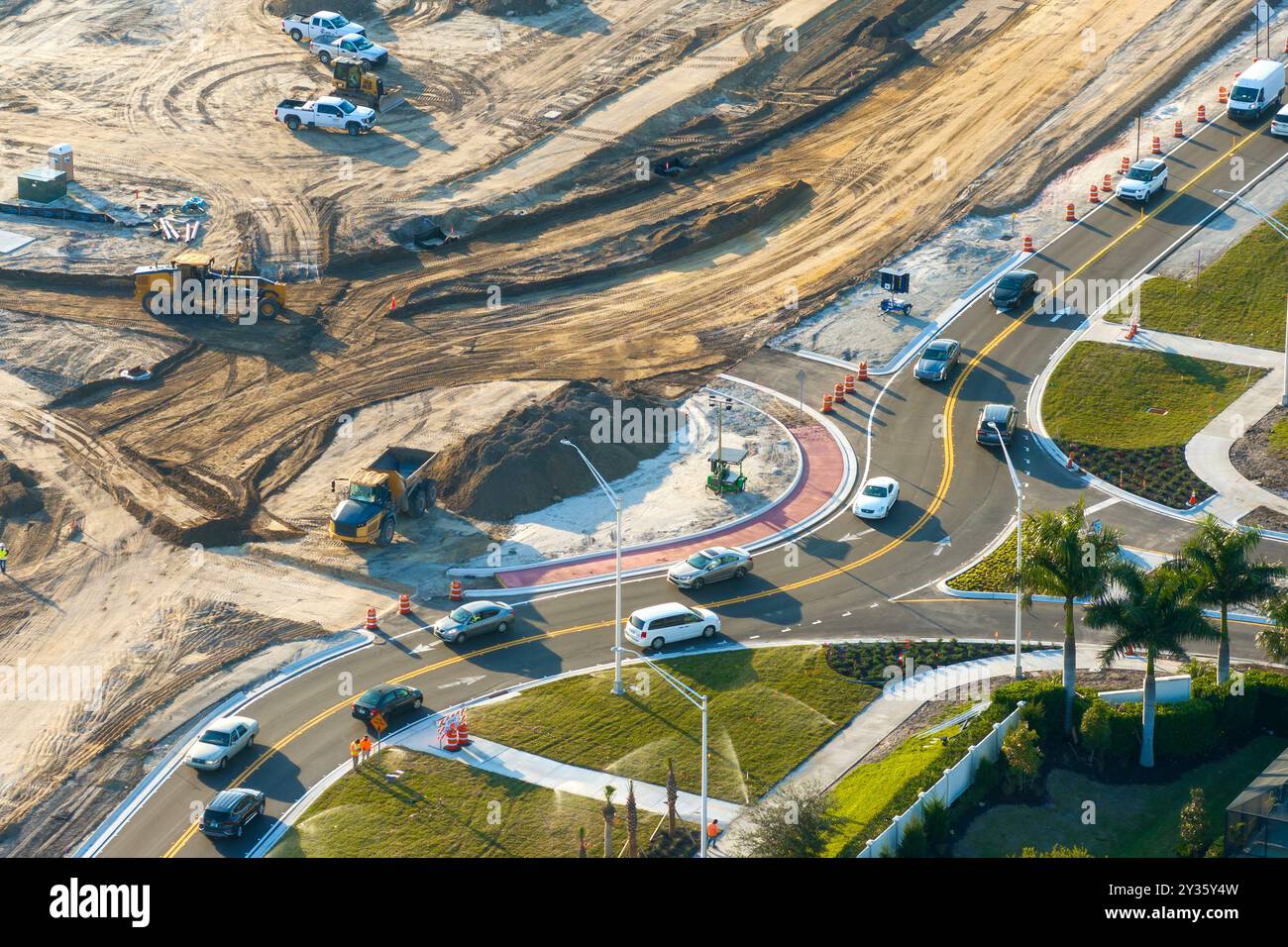 Driving traffic cars at roundabout intersection under construction ...