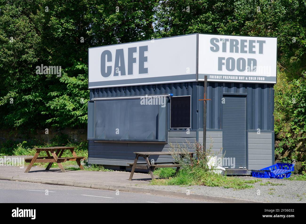 Street food cafe housed in portable container and outdoor tables Stock ...