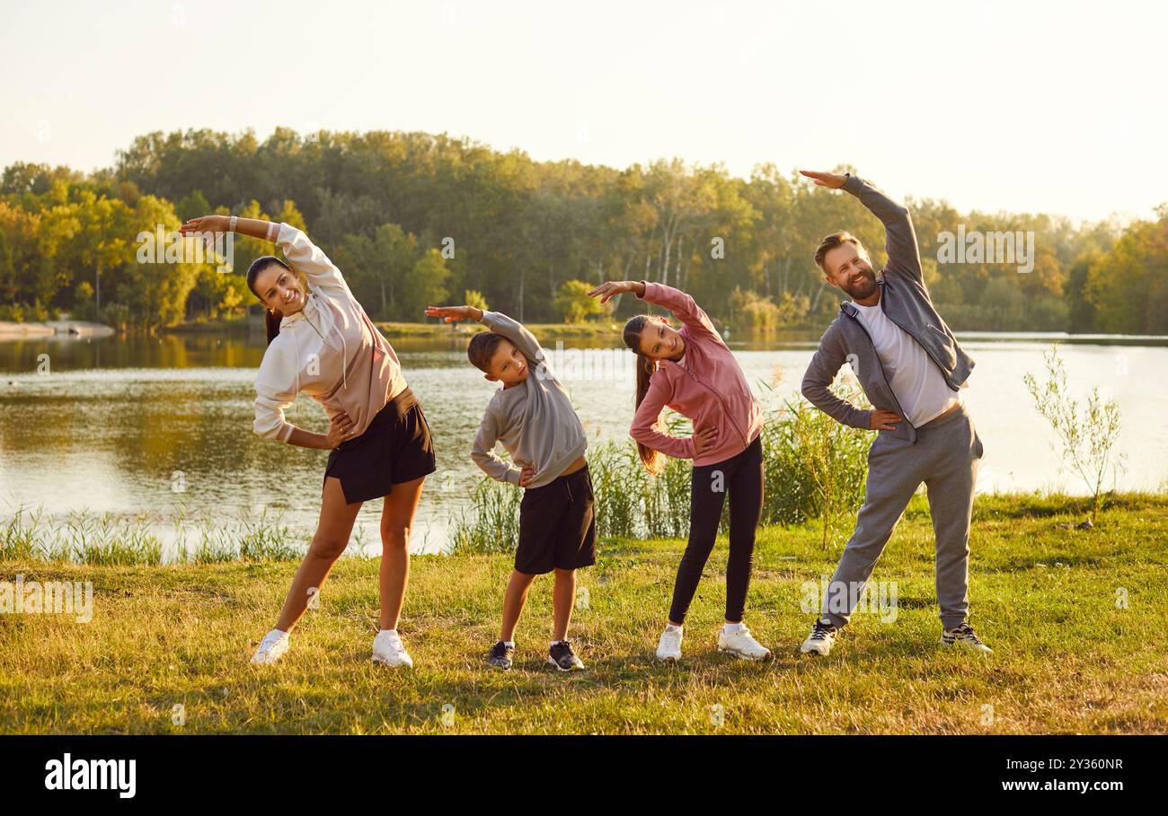 Happy sporty active family in sportswear doing side bending exercises ...