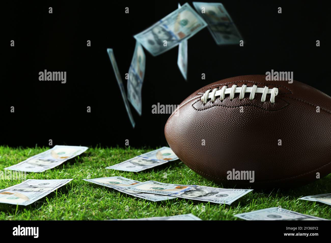 American football ball and dollar banknotes on green grass Stock Photo ...