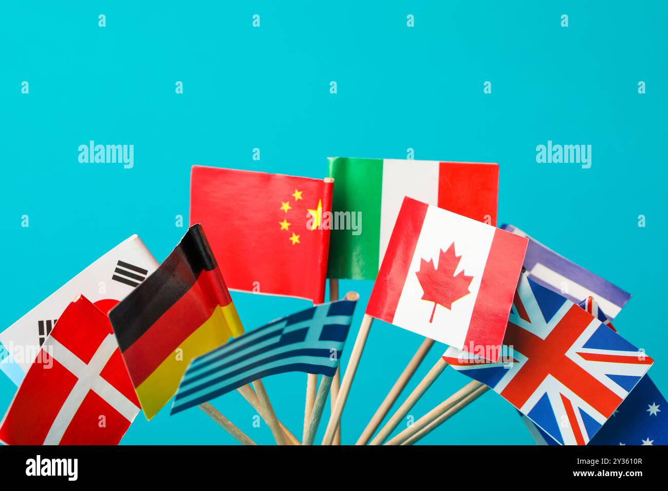 Small paper flags of different countries on light blue background Stock ...