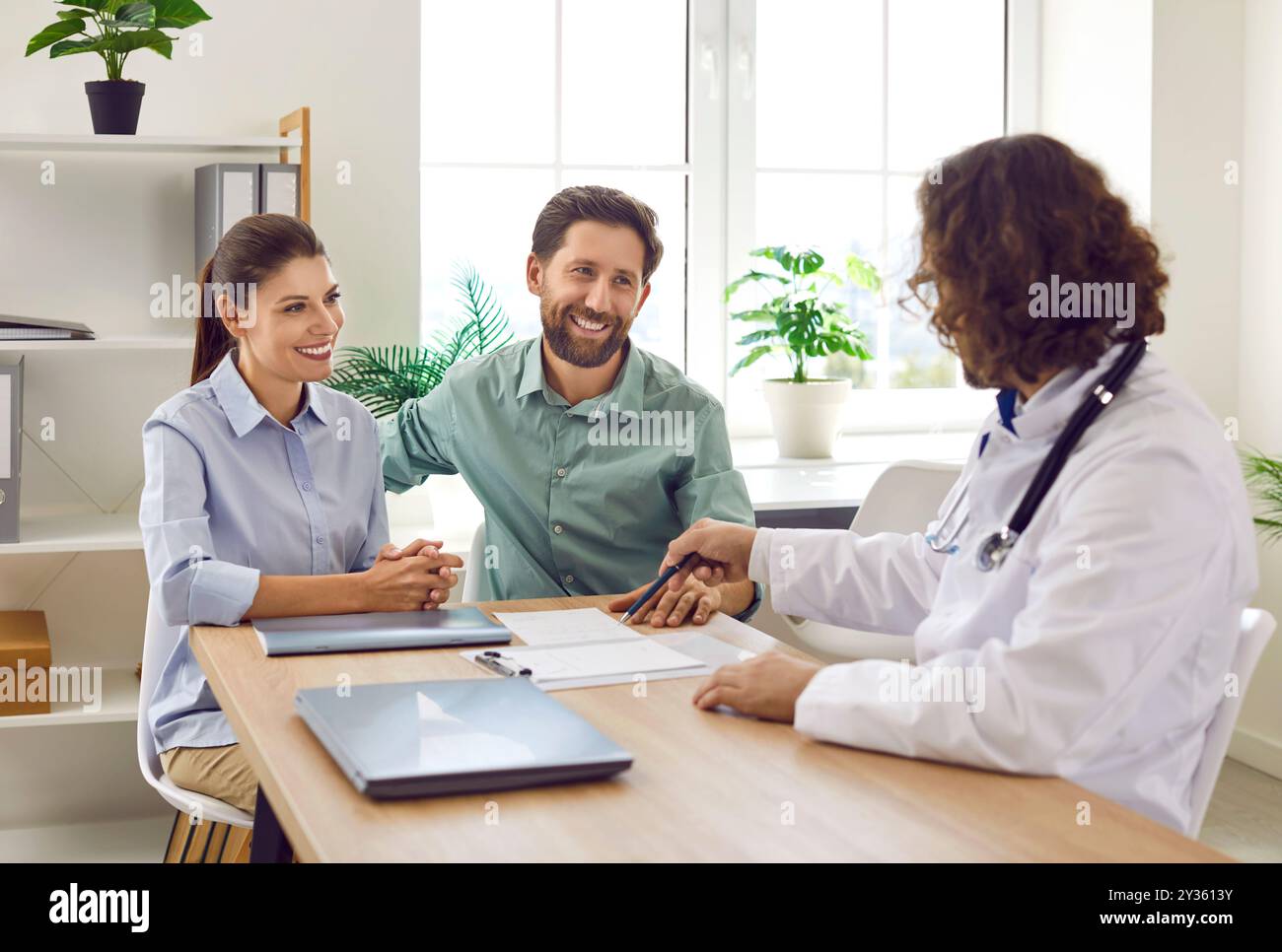 Young married couple signs contract with doctor in modern obstetrics ...