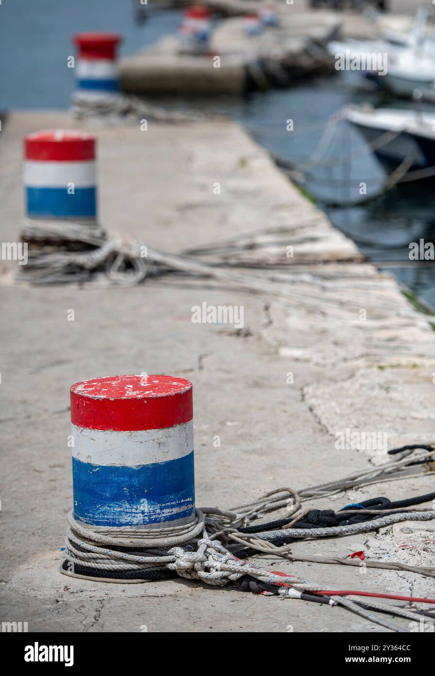 bollards on a harbour wall with ropes and wires for tying up ships and ...