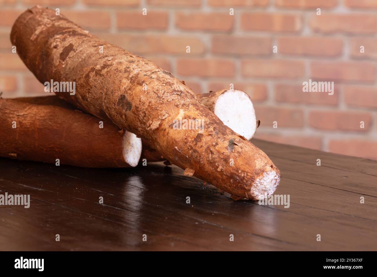 Three cassava roots on a table Stock Photo - Alamy