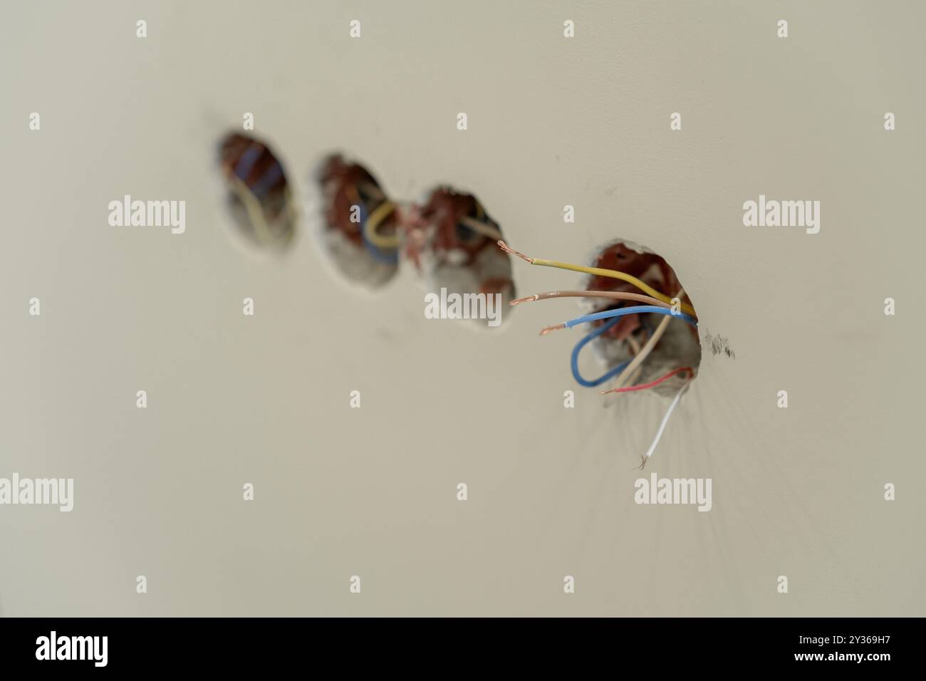 Electrician connects colorful wires into electrical boxes as part of ...