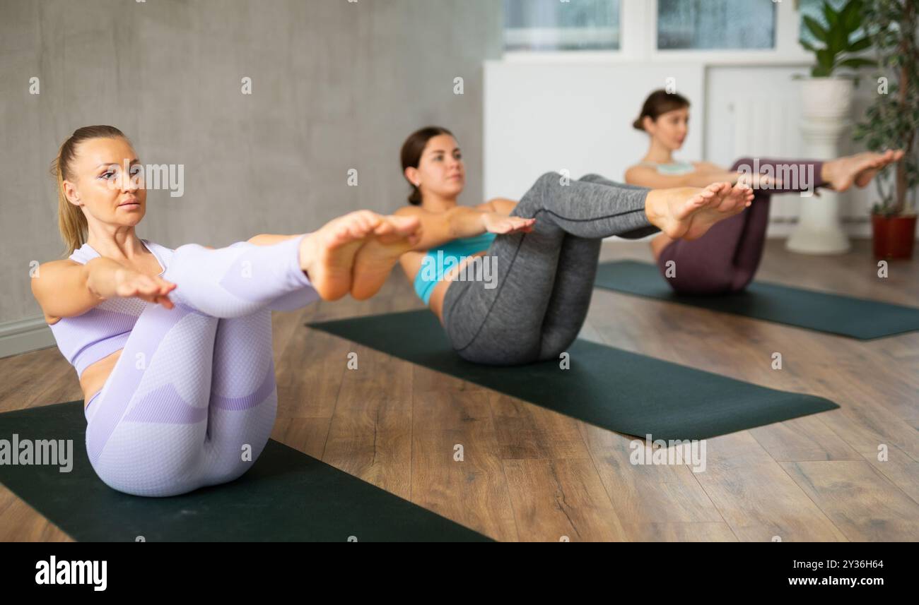 Group of active women practice various yoga poses Stock Photo - Alamy