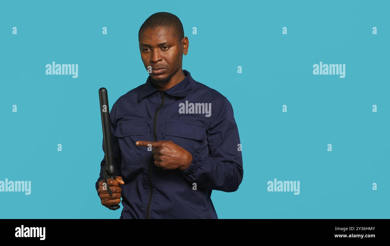 Security guard removing baton from belt, preparing to attack suspects ...