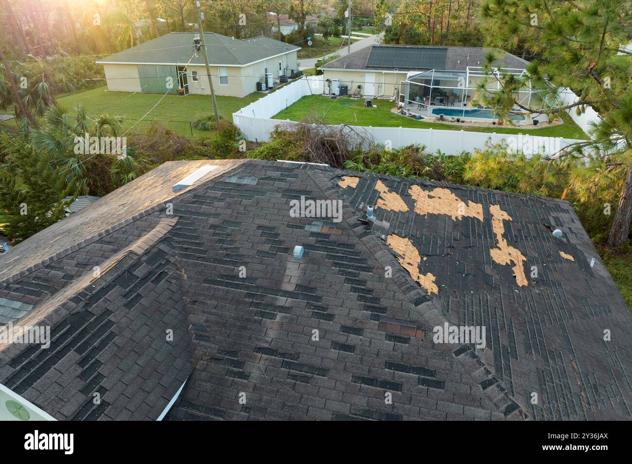Damaged house roof with missing shingles after hurricane Ian in Florida ...