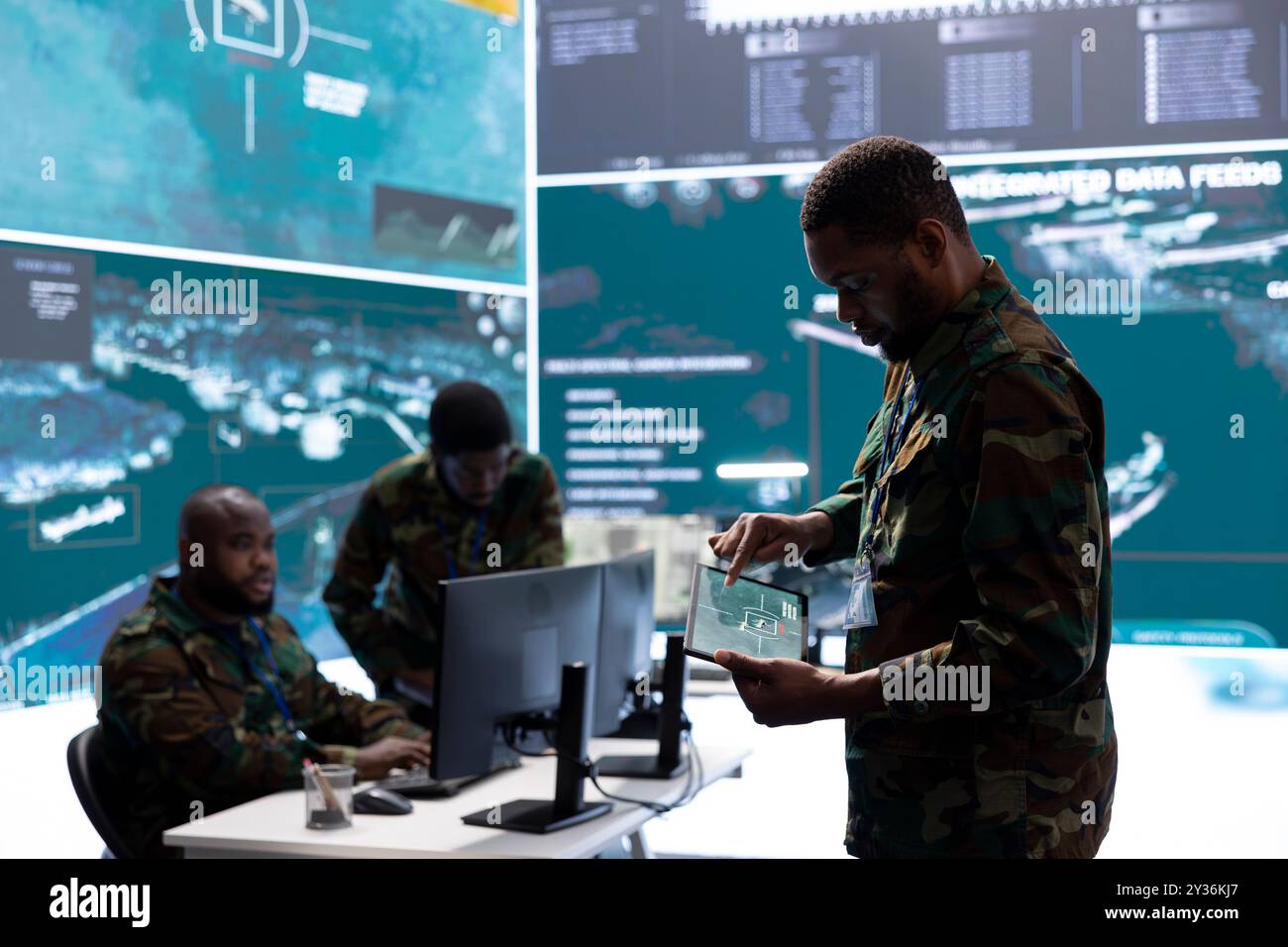 Military team in a control center uses advanced technology to gather crucial information ...