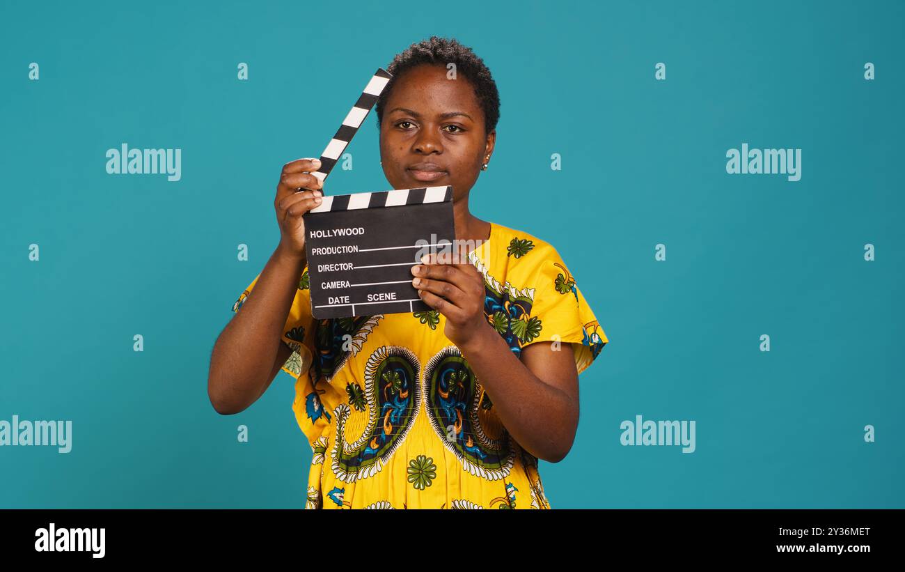 Young woman movie producer clapping filming slate to cut a scene ...