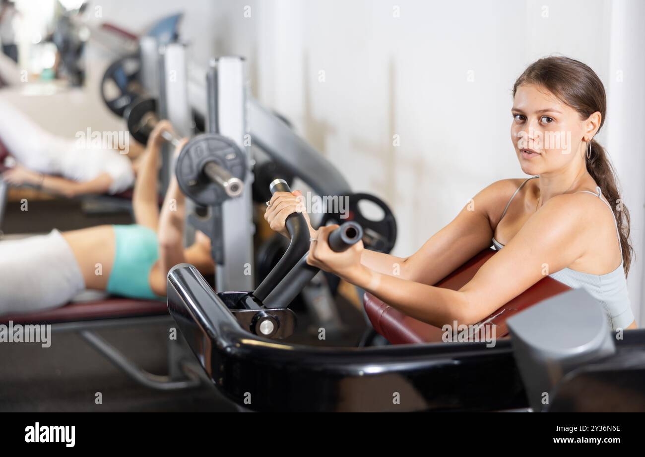 Slender athletic girl work out muscles of arms and shoulders on ...
