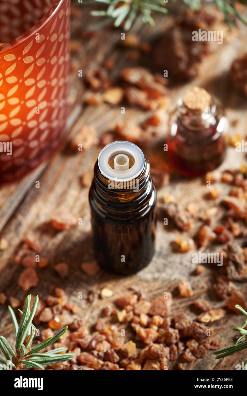A dropper bottle of essential oil with myrrh resin and a candle Stock ...