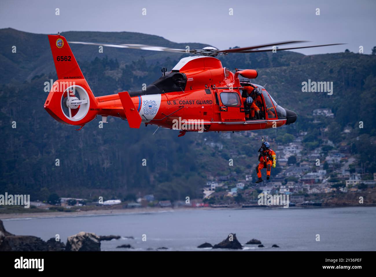 A flight mechanic aboard a Coast Guard Air Station San Francisco MH-65 ...