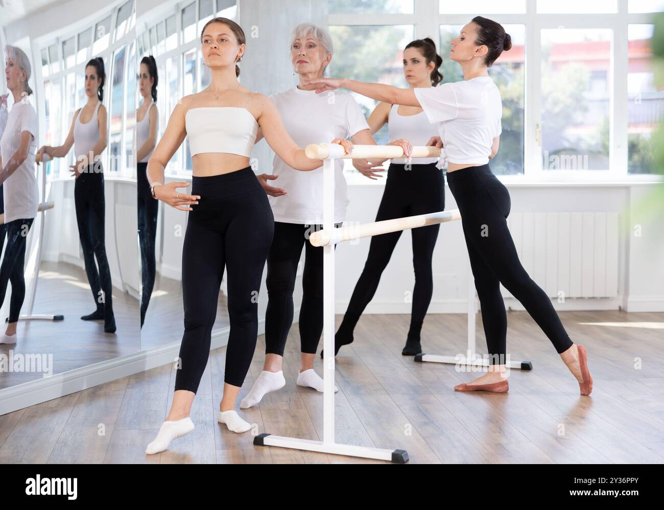 Teacher conducts class with girls in ballet studio, observes doing ...
