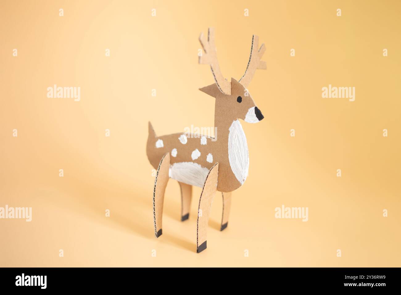 Paper craft model of a deer on a plain background, recycling concept ...