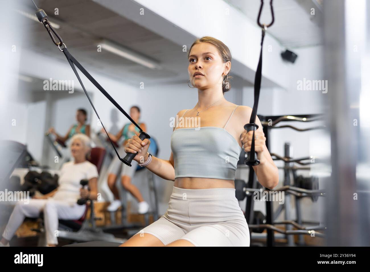Active athlete young woman during exercises on crossover exercise ...