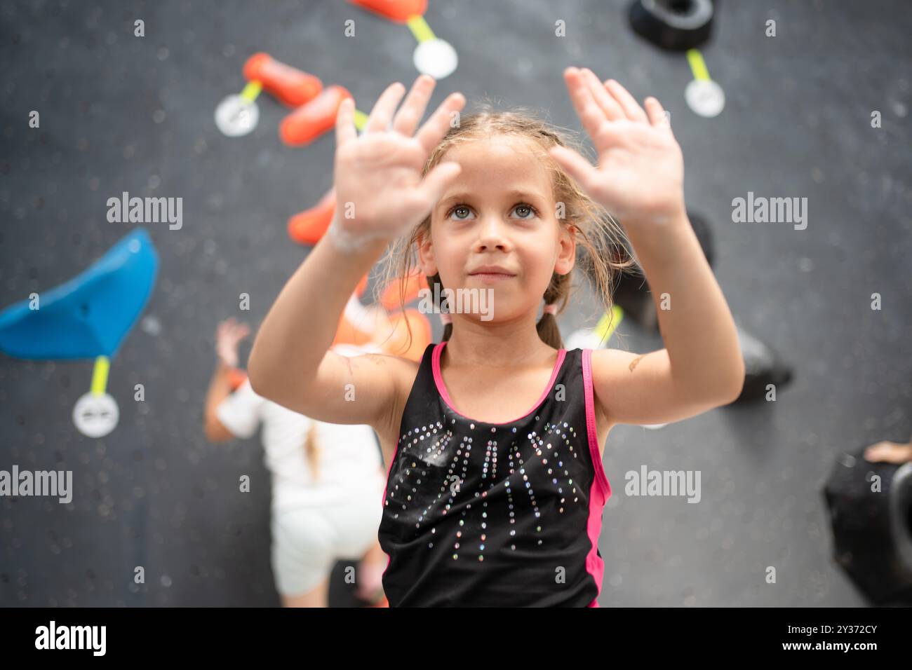 Cute adorable girl climber showing hands coated with powder chalk ...