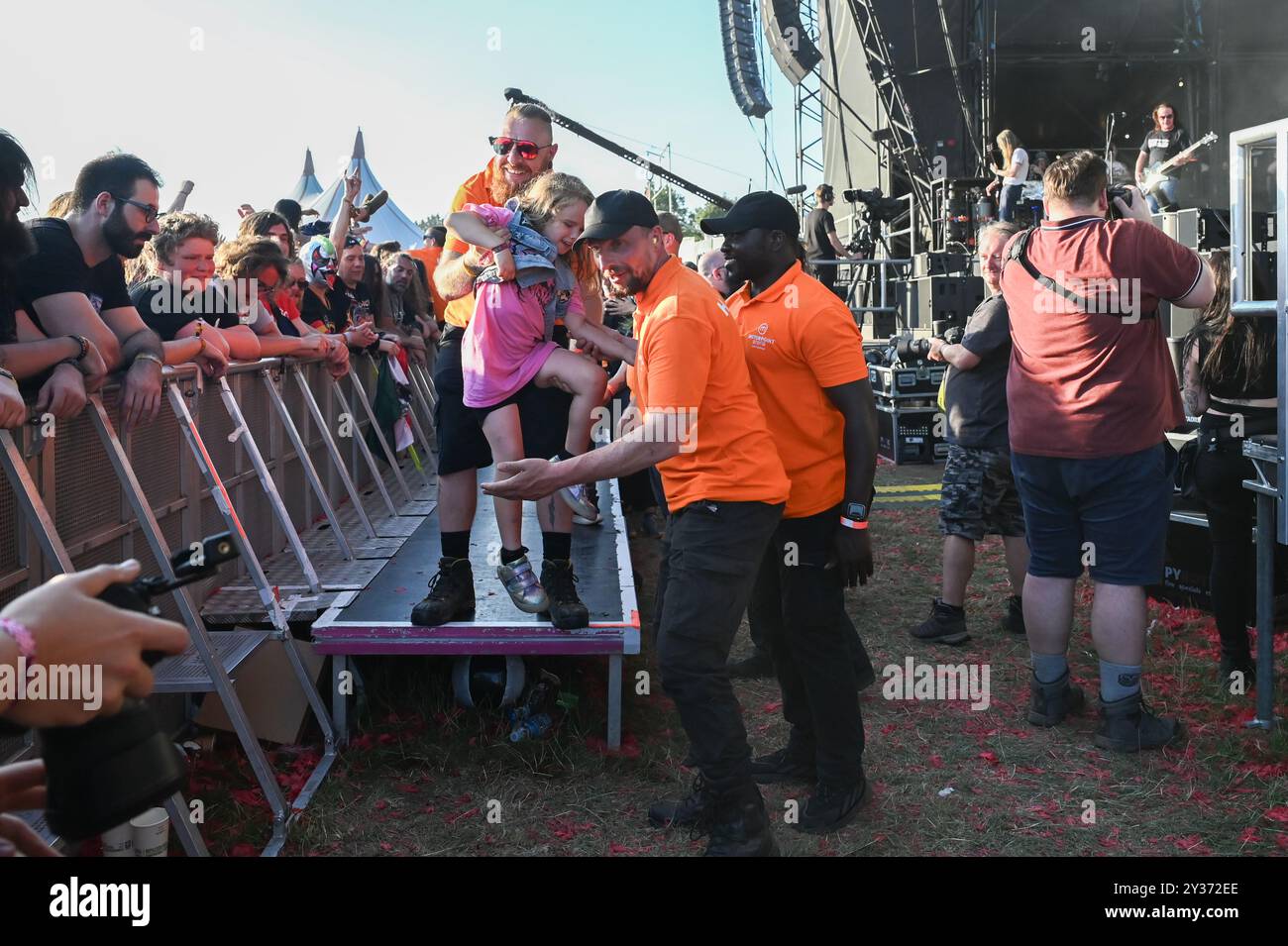 Security carry a young crowdsurfer safely over the crowd during ...
