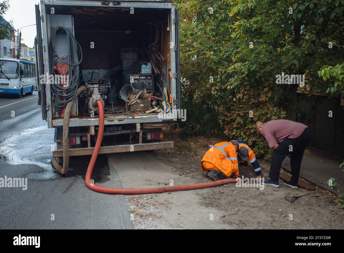 Sewer workers cleaning manhole and unblocking sewers the street ...