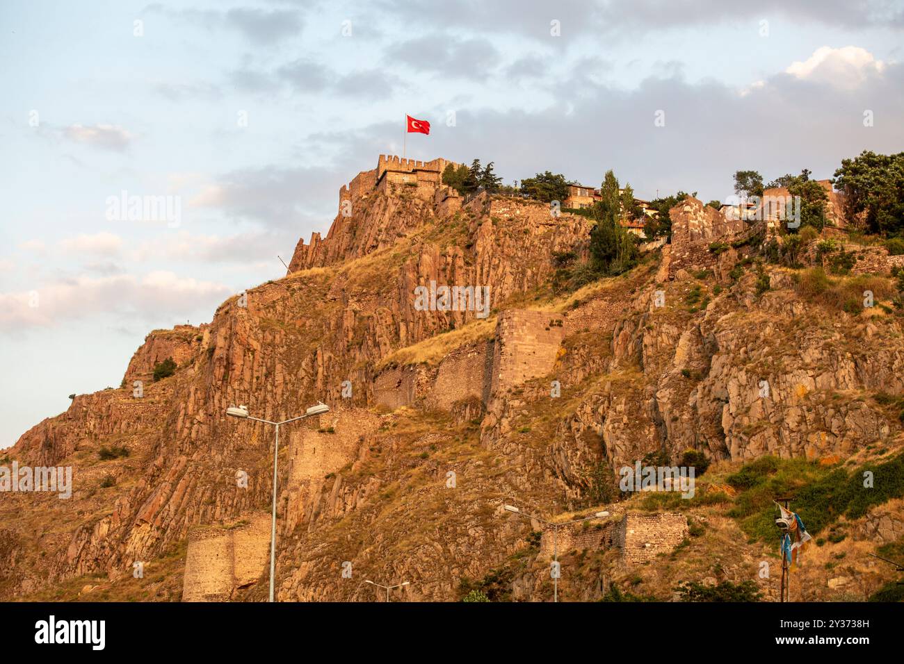 Rugged cliffs and weathered fortifications of Ankara Castle stand ...