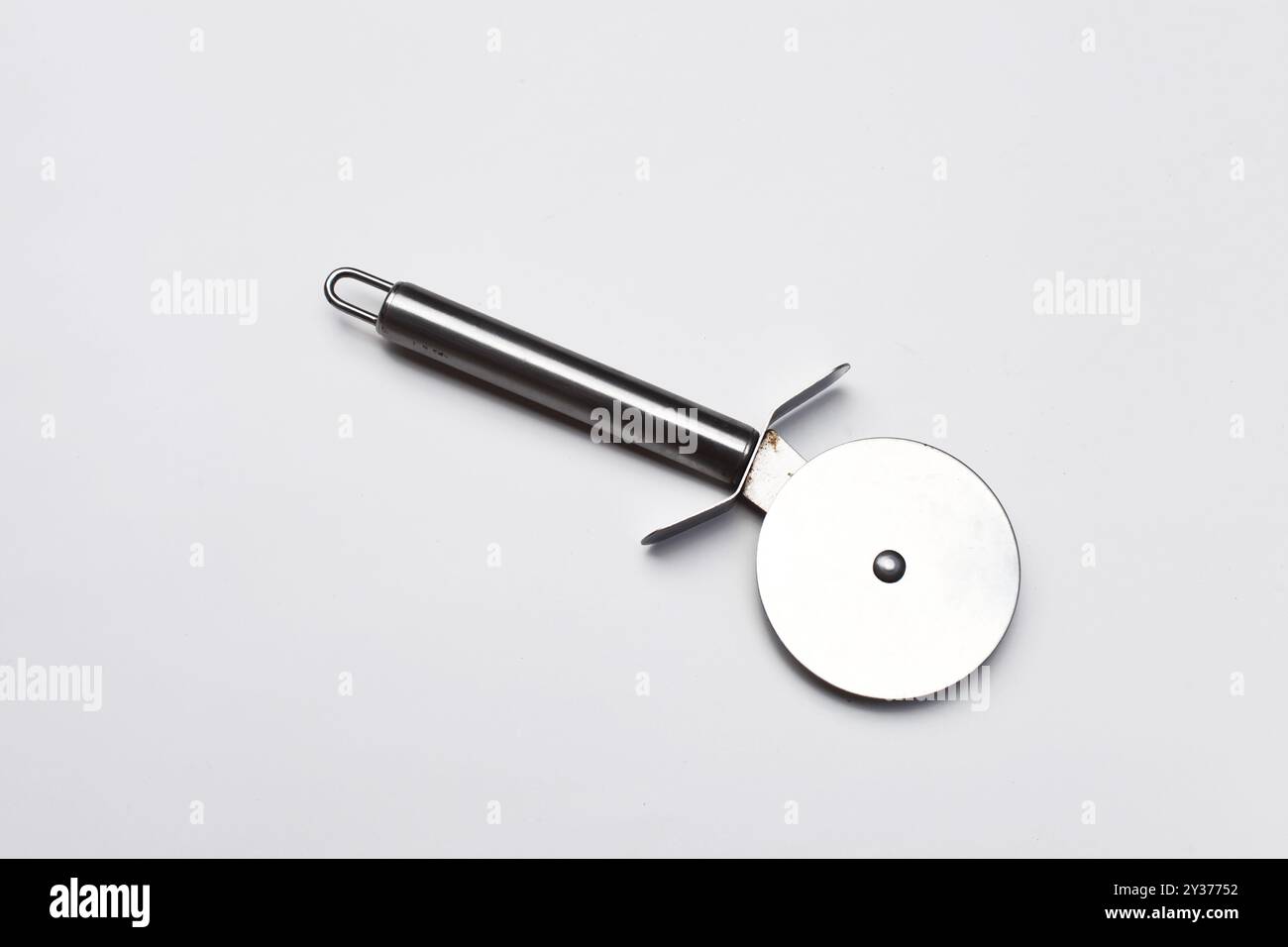 Stainless steel pizza cutter on a white background Stock Photo - Alamy